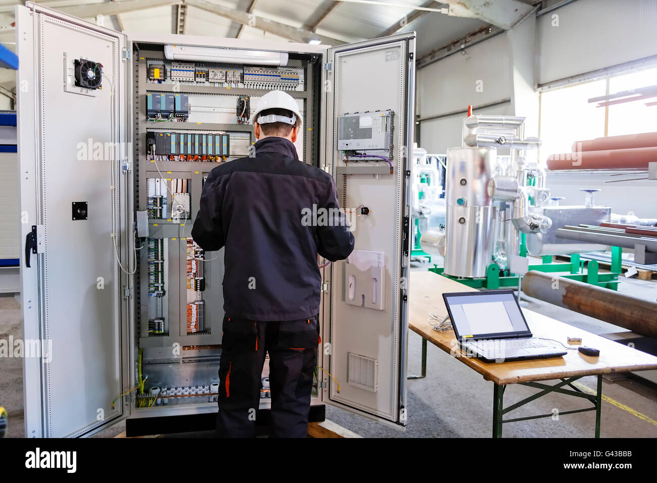 Man worker checking advanced industrial control panel in the production ...