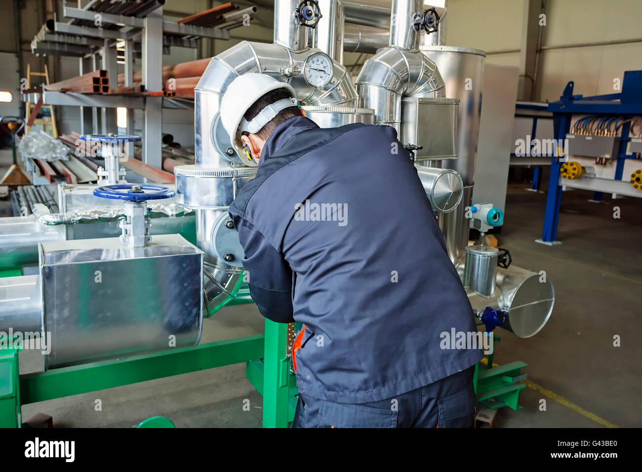 Man worker checking advanced industrial engine in the production hall ...