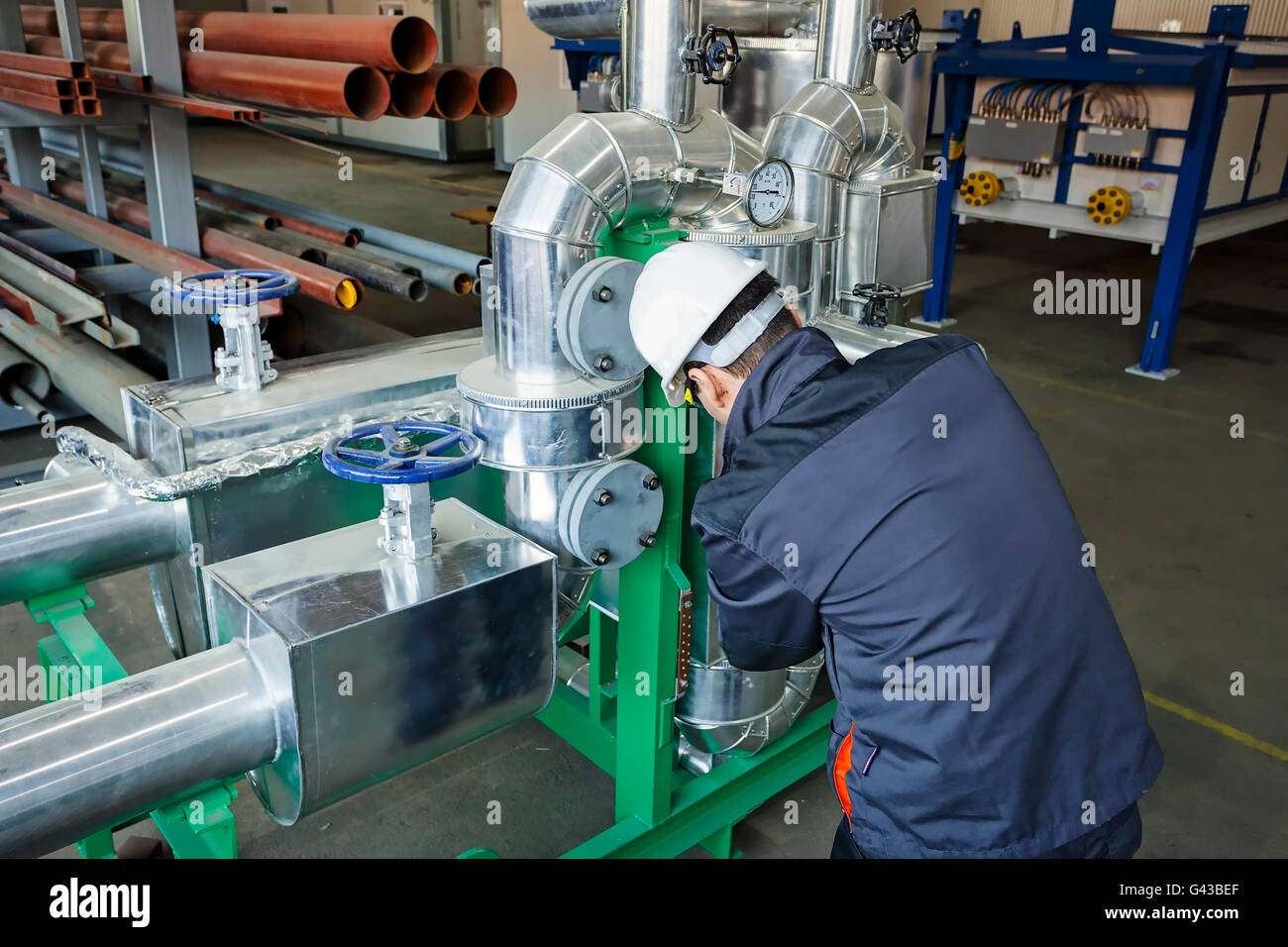 Man worker checking advanced industrial engine in the production hall ...