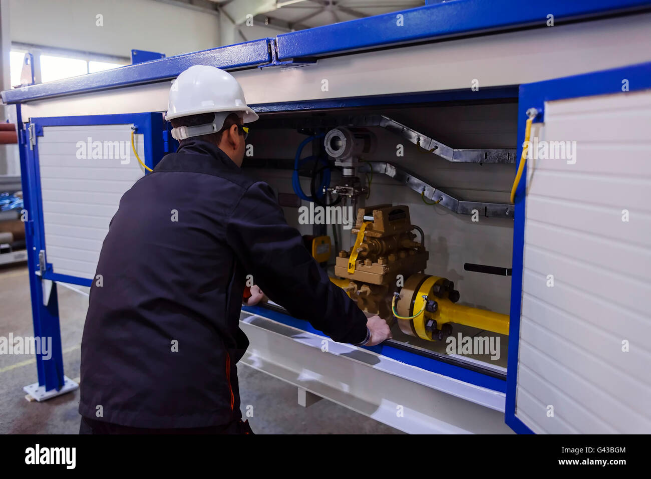 Man worker in a safety clothes performing quality control in production ...