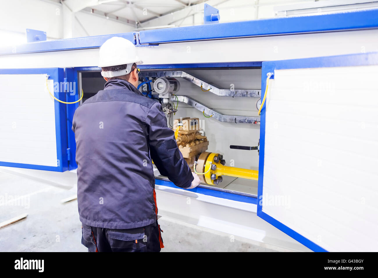 Man worker in a safety clothes performing quality control in production ...