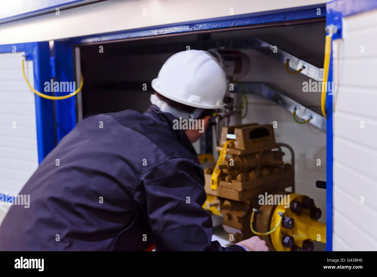 Man worker in a safety clothes performing quality control in production ...