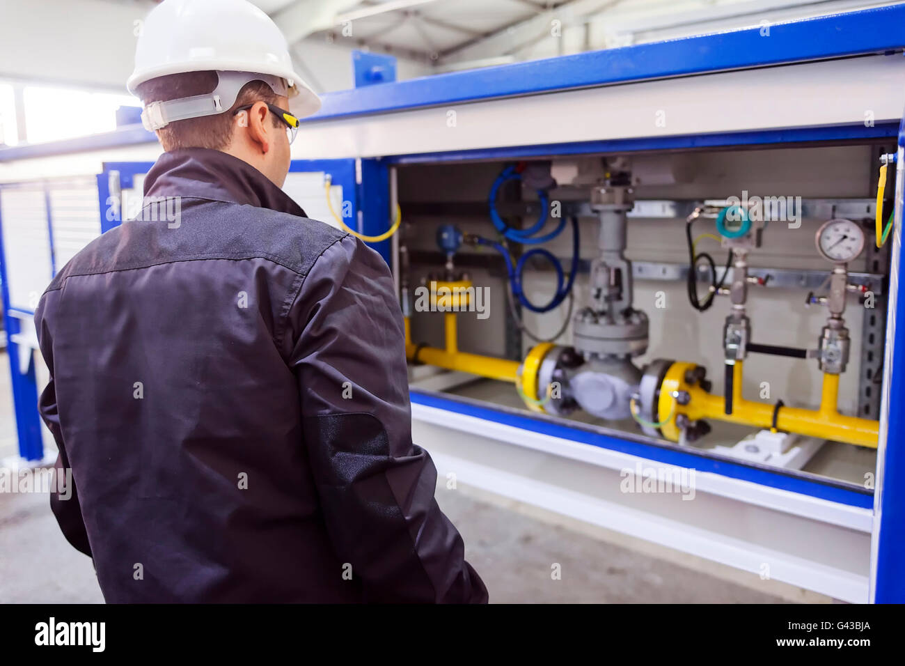 Man worker in a safety clothes performing quality control in production ...
