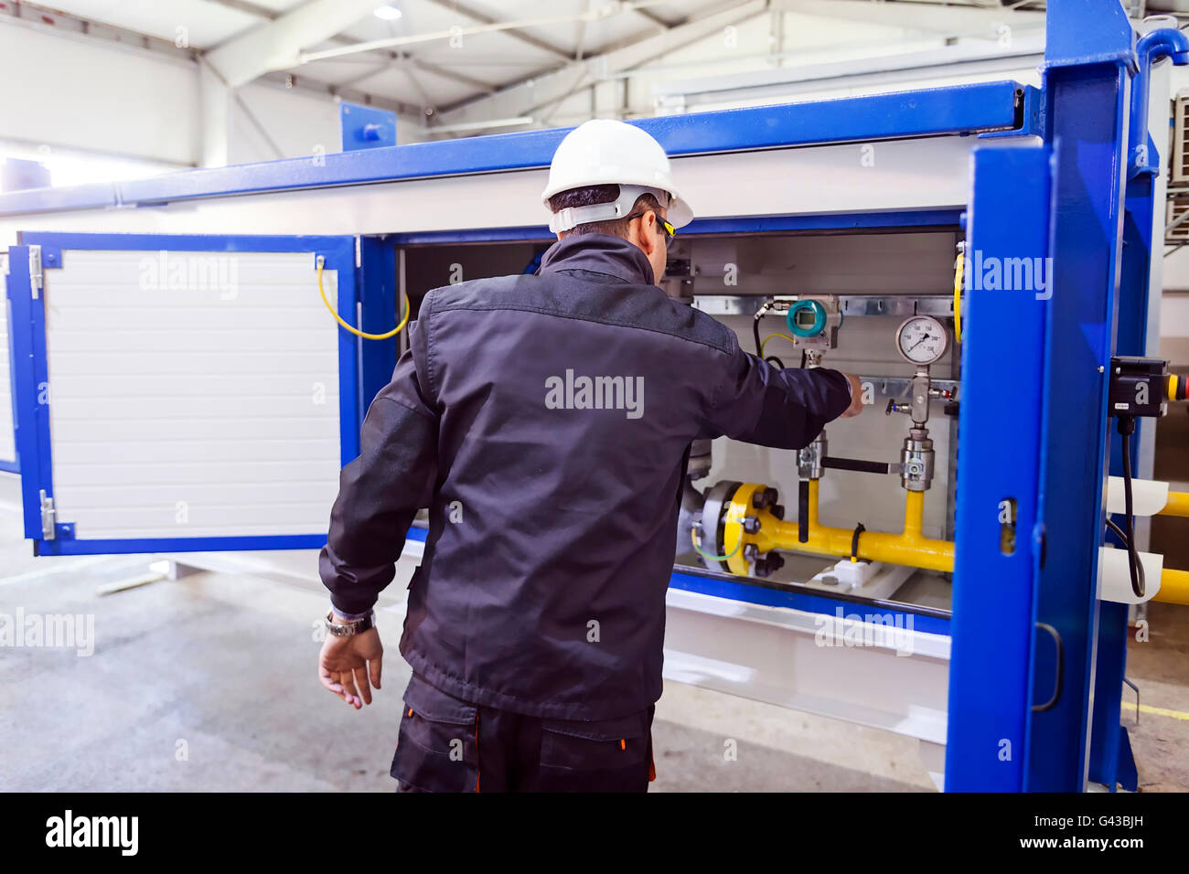 Man worker in a safety clothes performing quality control in production ...