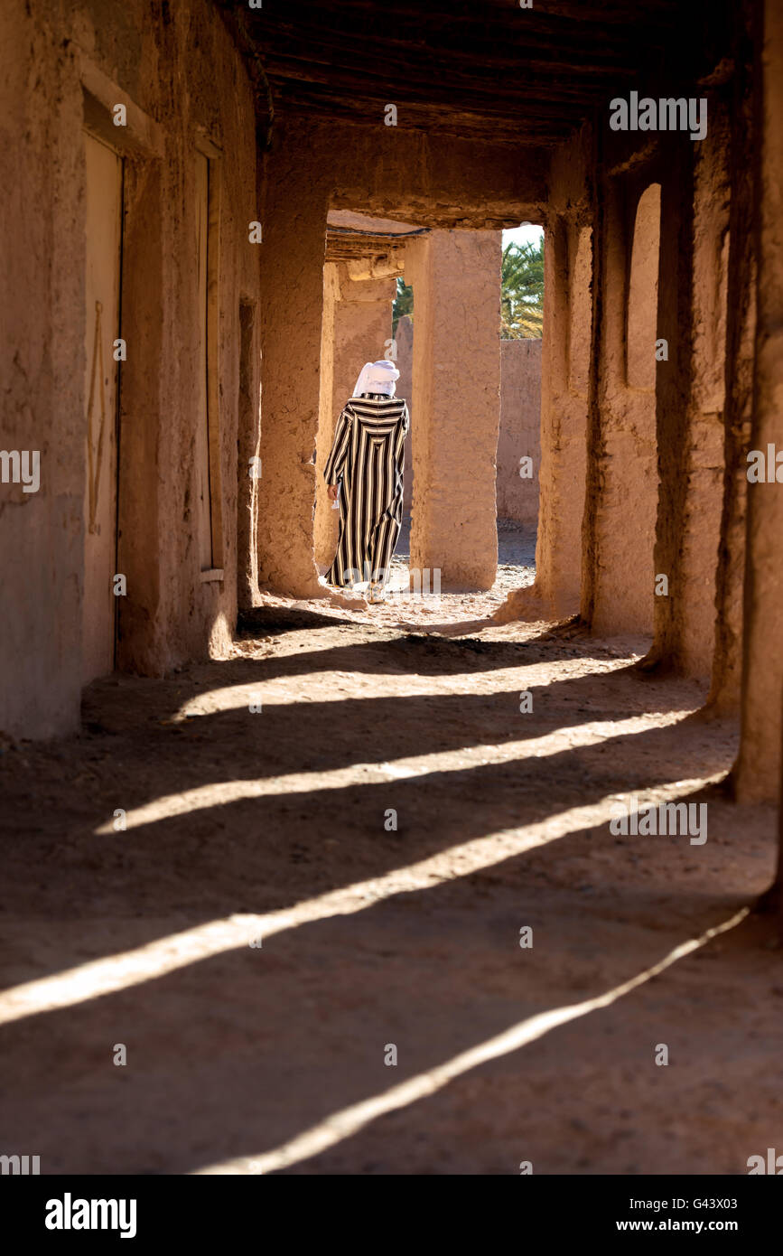 Traditional dressed man walks through an arch way Stock Photo - Alamy