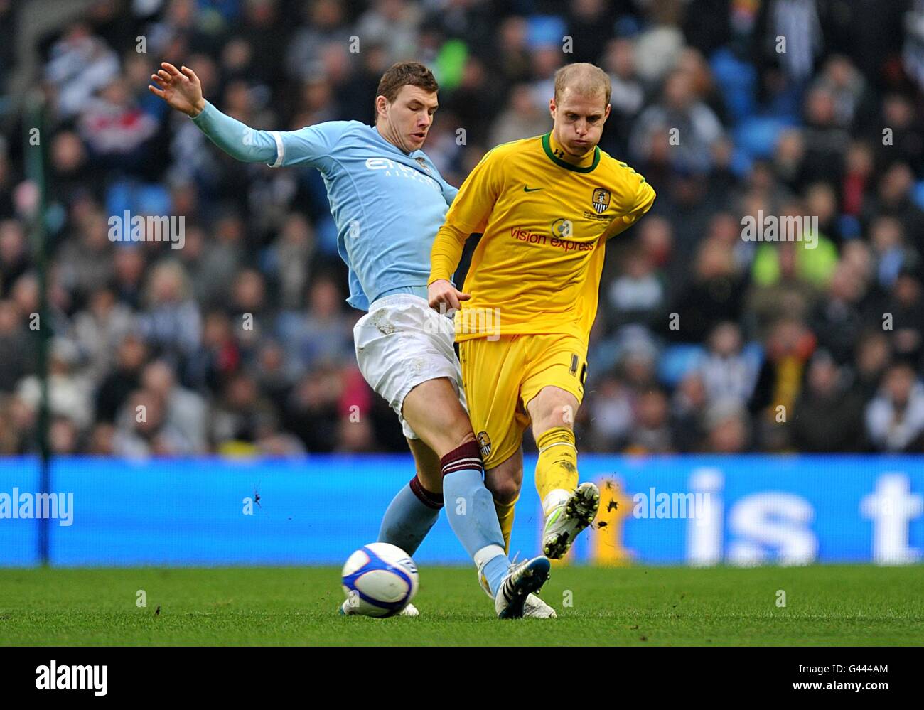 Manchester City's Edin Dzeko (left) and Notts County's Neal Bishop ...