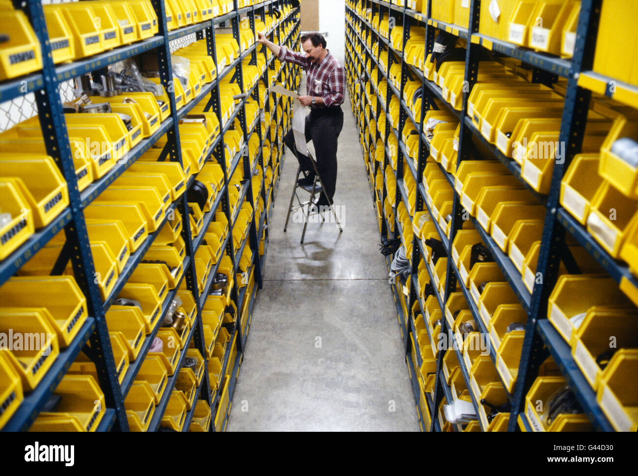 Male worker selecting parts from large distribution warehouse Stock ...