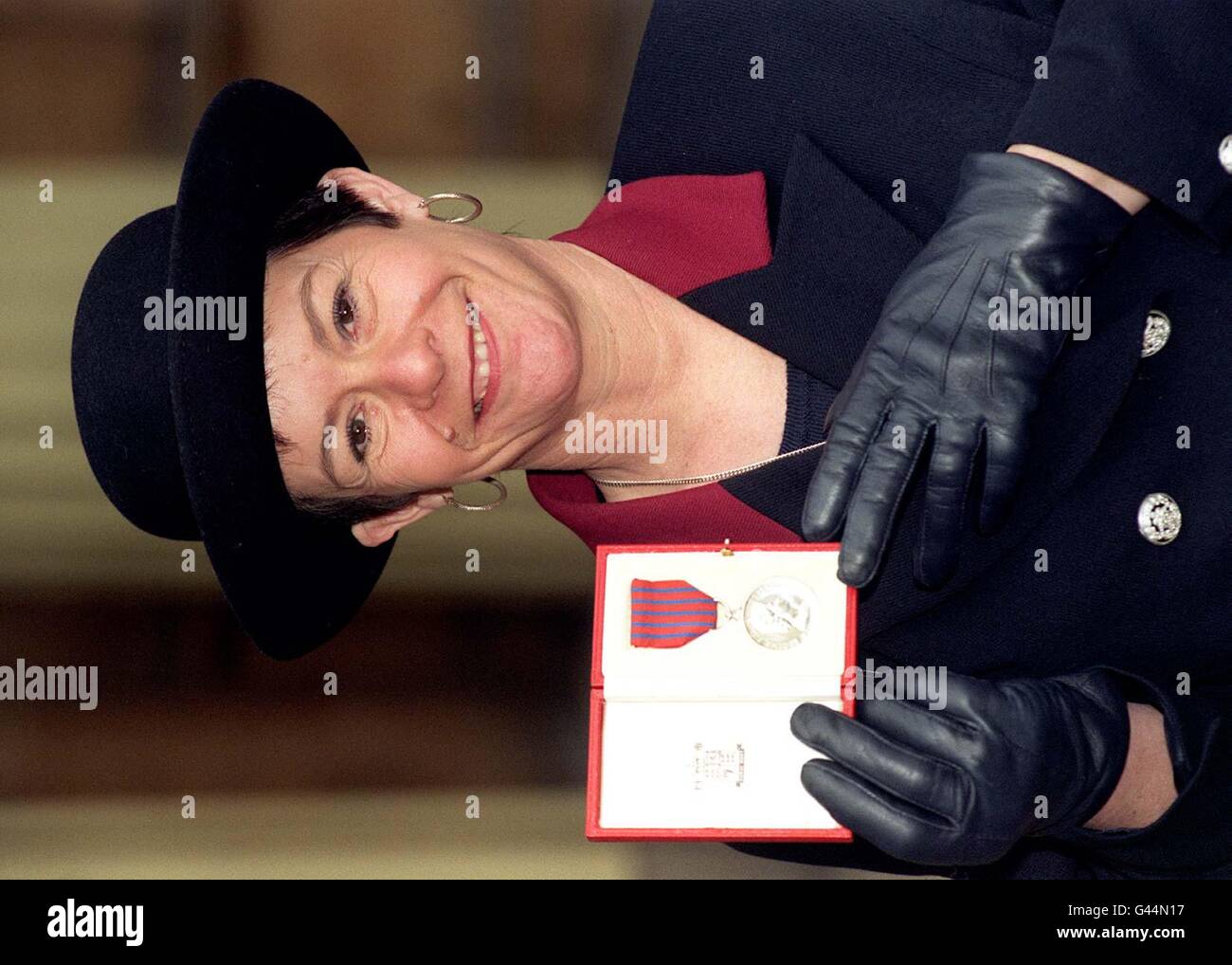 Mrs Elizabeth Mee holding up the George Medal awarded to her late ...