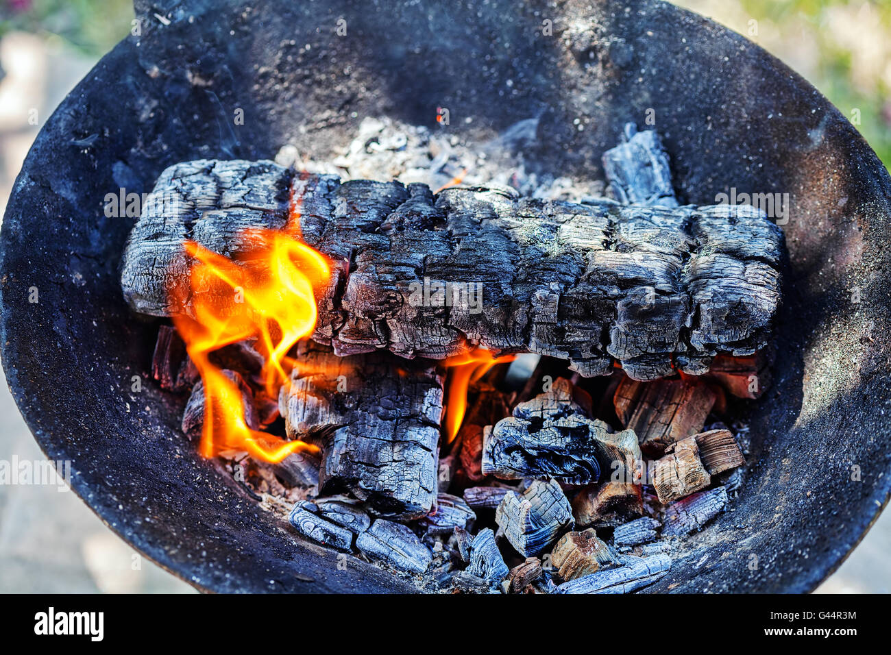 Wood burning with flames, ash and smoke in a barbecue Stock Photo - Alamy