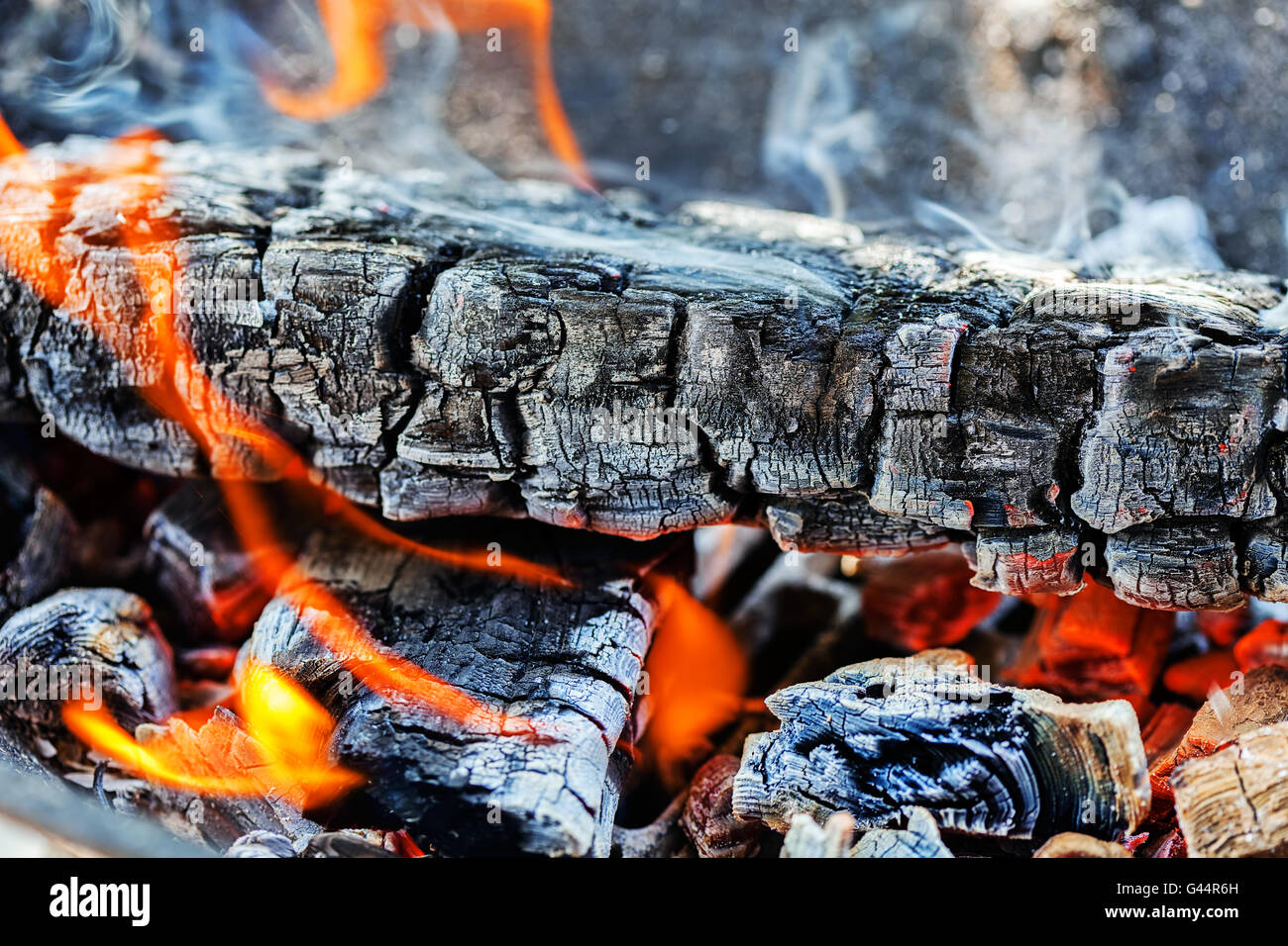 Wood burning with flames, ash and smoke in a barbecue Stock Photo - Alamy