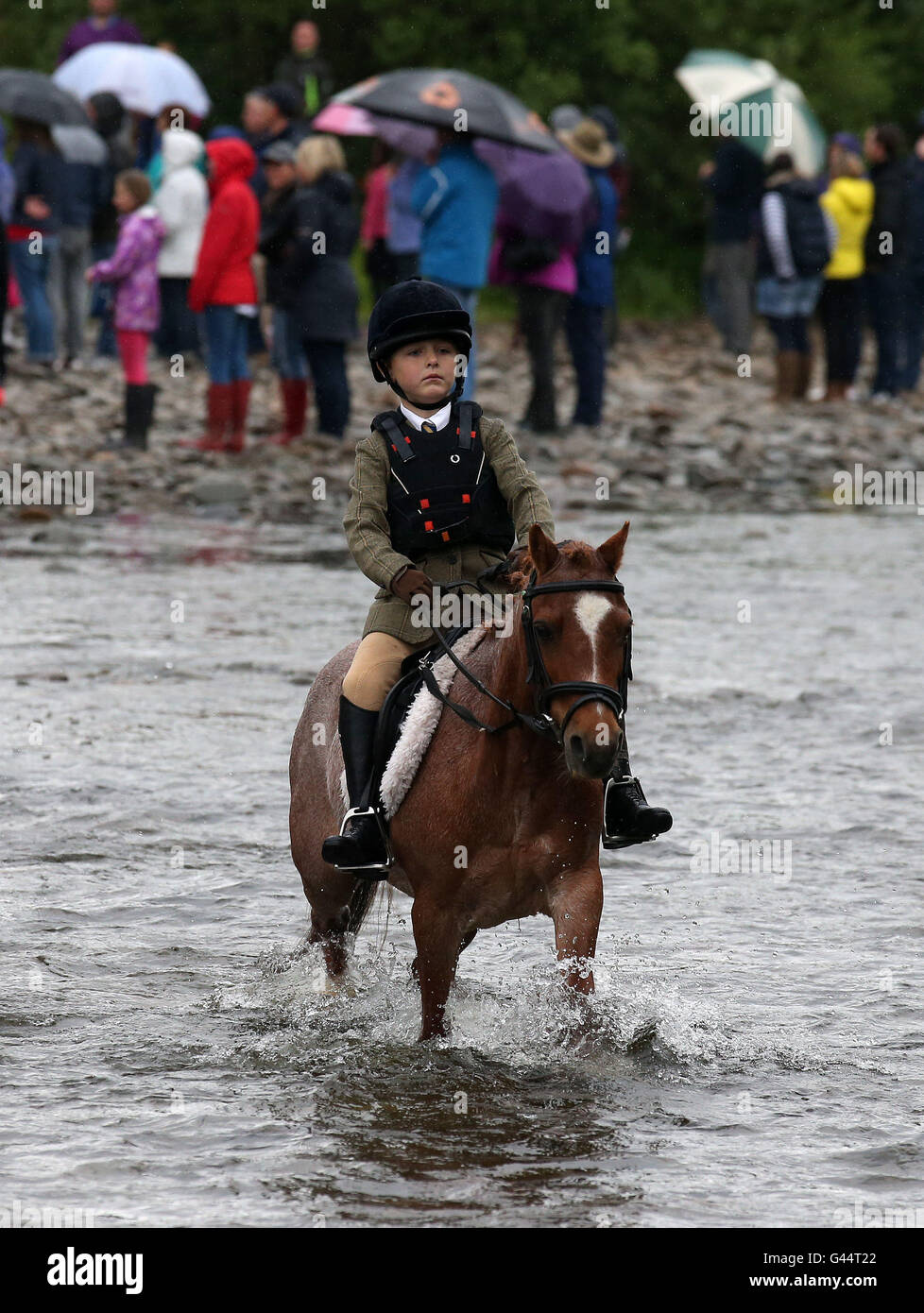A young rider crosses a ford on the River Ettrick as he takes part in ...