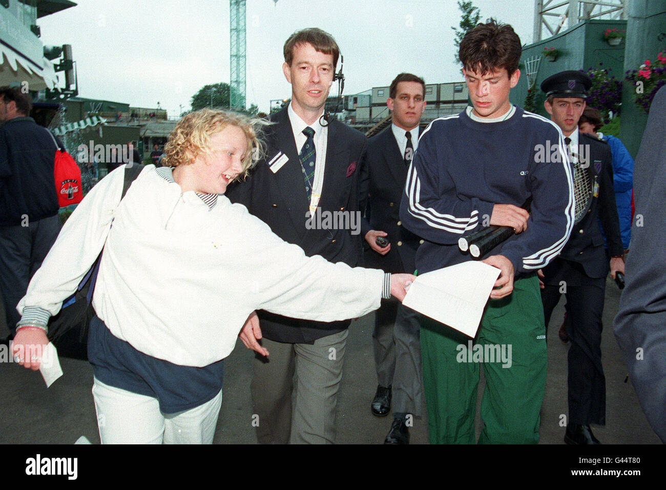 A young fan reaches over for Tim Henman's autograph as he arrives at ...