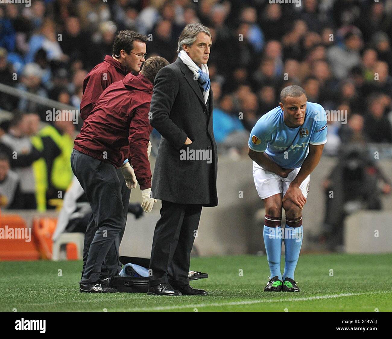 Manchester City's Vincent Kompany (right) reacts after suffering an ...