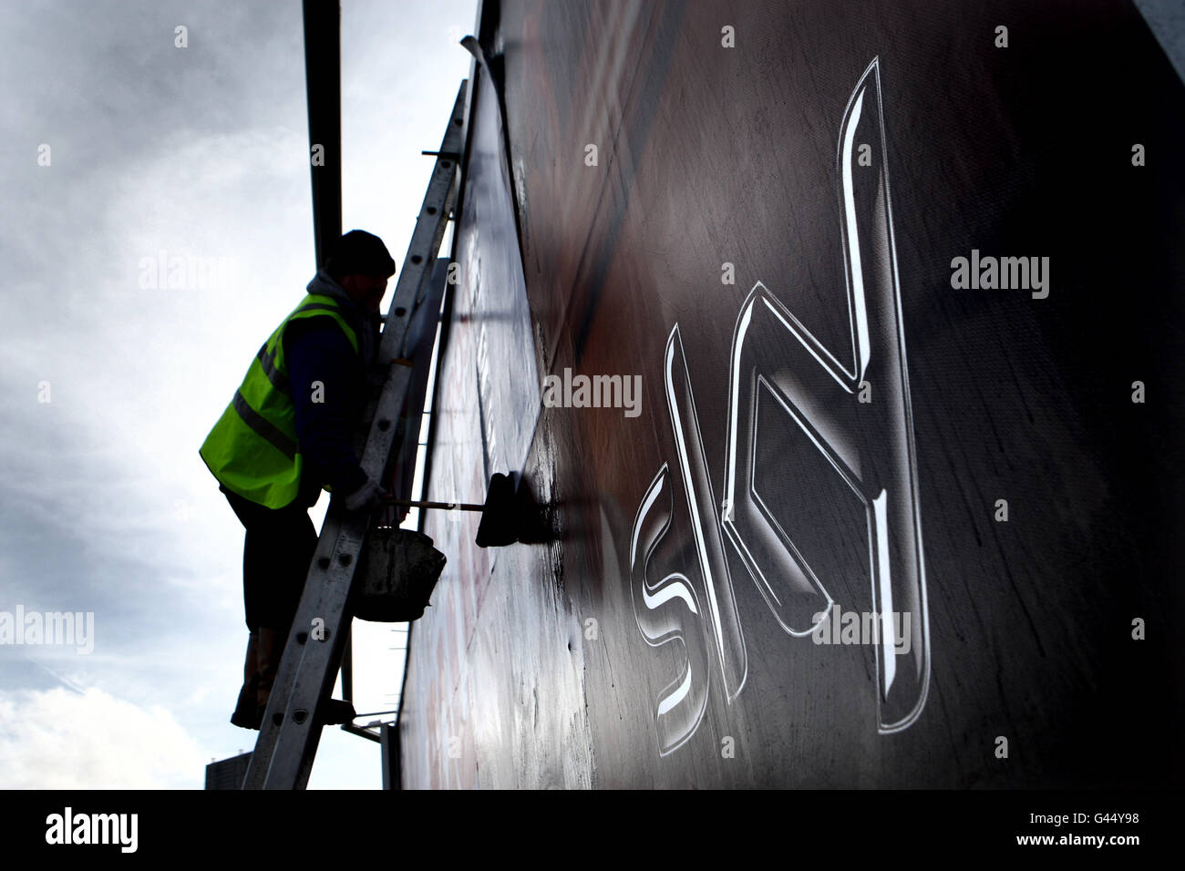 A worker erects a Sky TV poster in Birmingham Stock Photo - Alamy