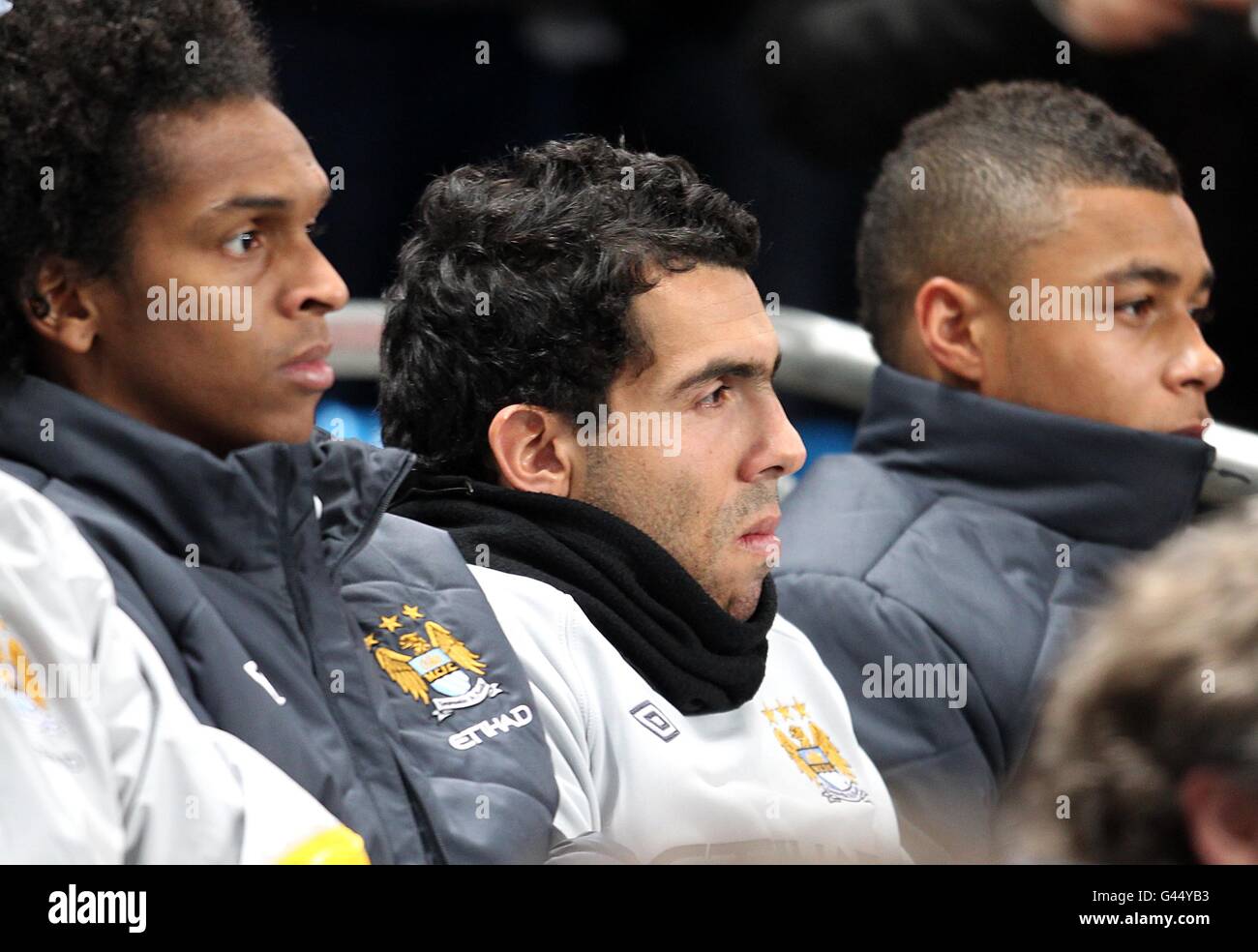 Manchester City's Carlos Tevez (centre) sits on the bench alongside ...
