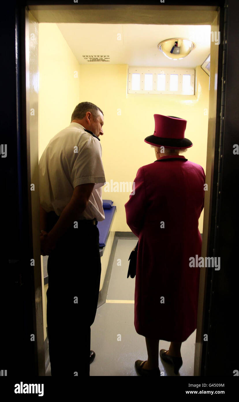 Queen Elizabeth II and the Duke of Edinburgh visit a cell accompanied ...