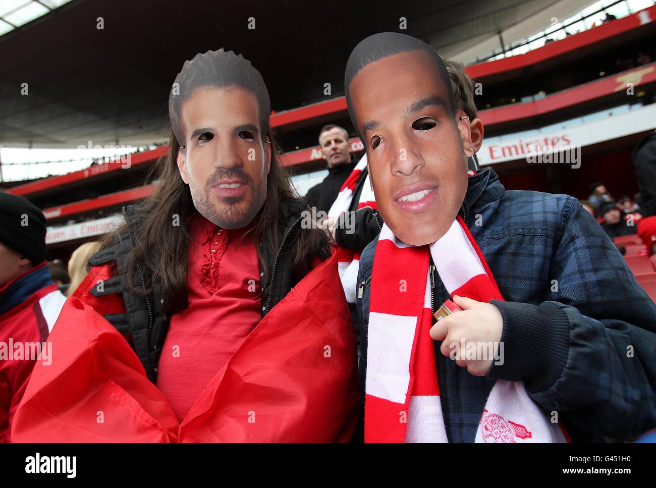 Arsenal fans wear masks of Theo Wallcott and Francesc Fabregas Stock ...
