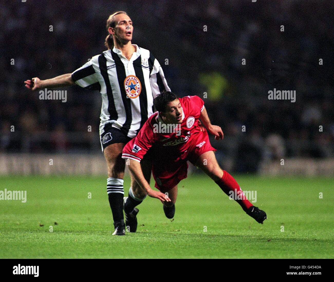 Rough treatment for Liverpool's Robbie Fowler as he is knocked over by ...