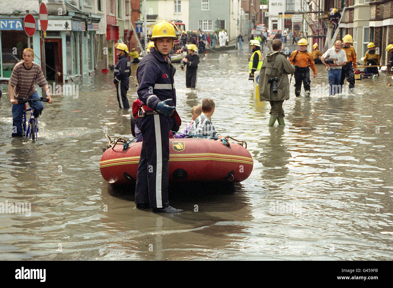 A fireman uses an inflatable boat to rescue several young children in ...
