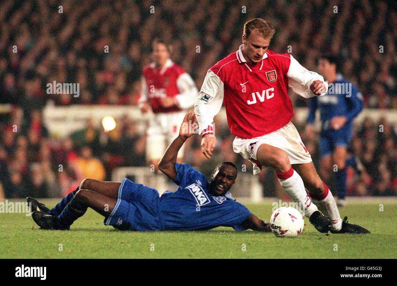 Everton's Earl Barrett takes a slide as Arsenal's Dennis Bergkamp takes ...