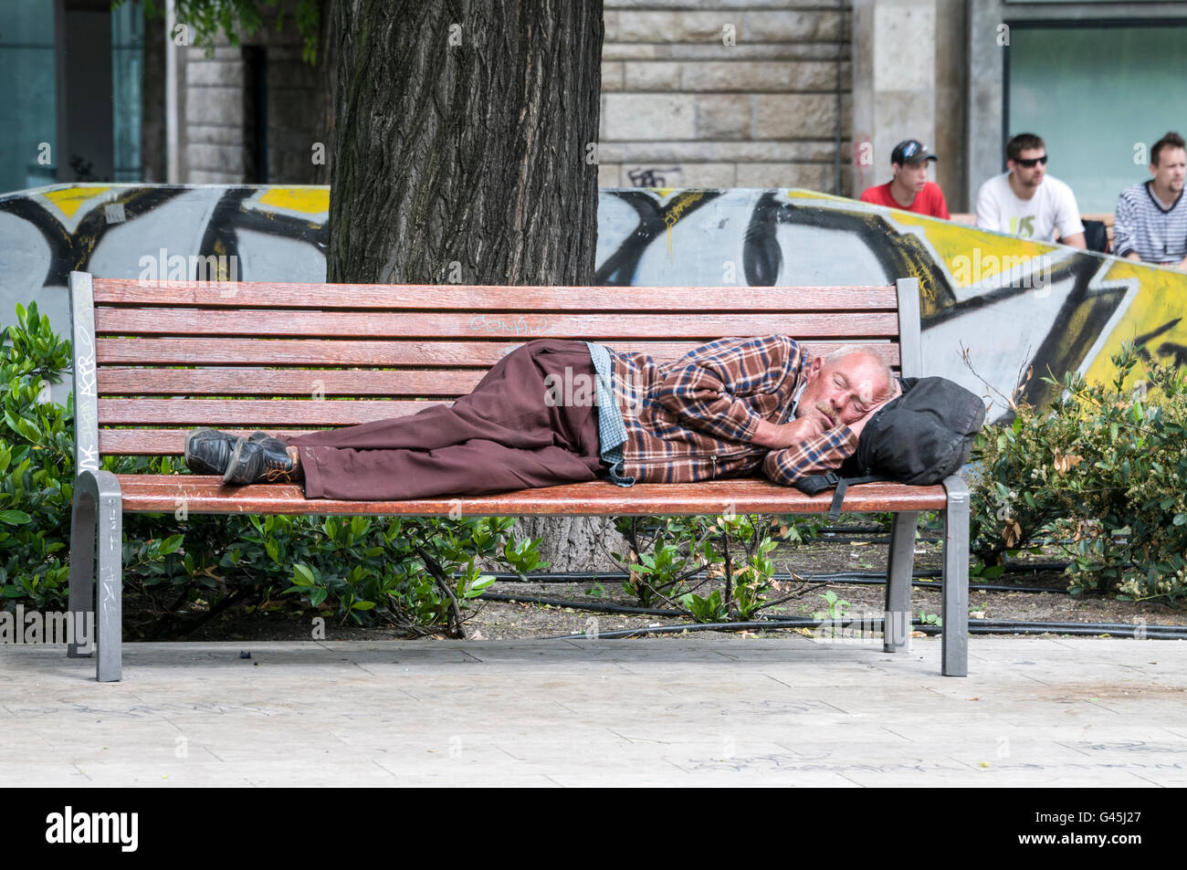 A homeless man sleeping on a park bench in Erzsébet Square (Erzsébet ...