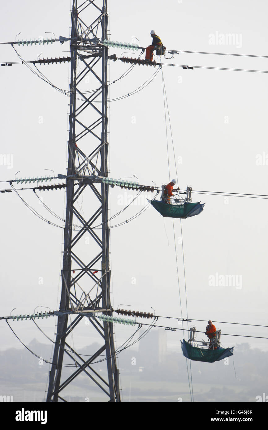 Engineers work in gondolas attached to high voltage power lines high ...