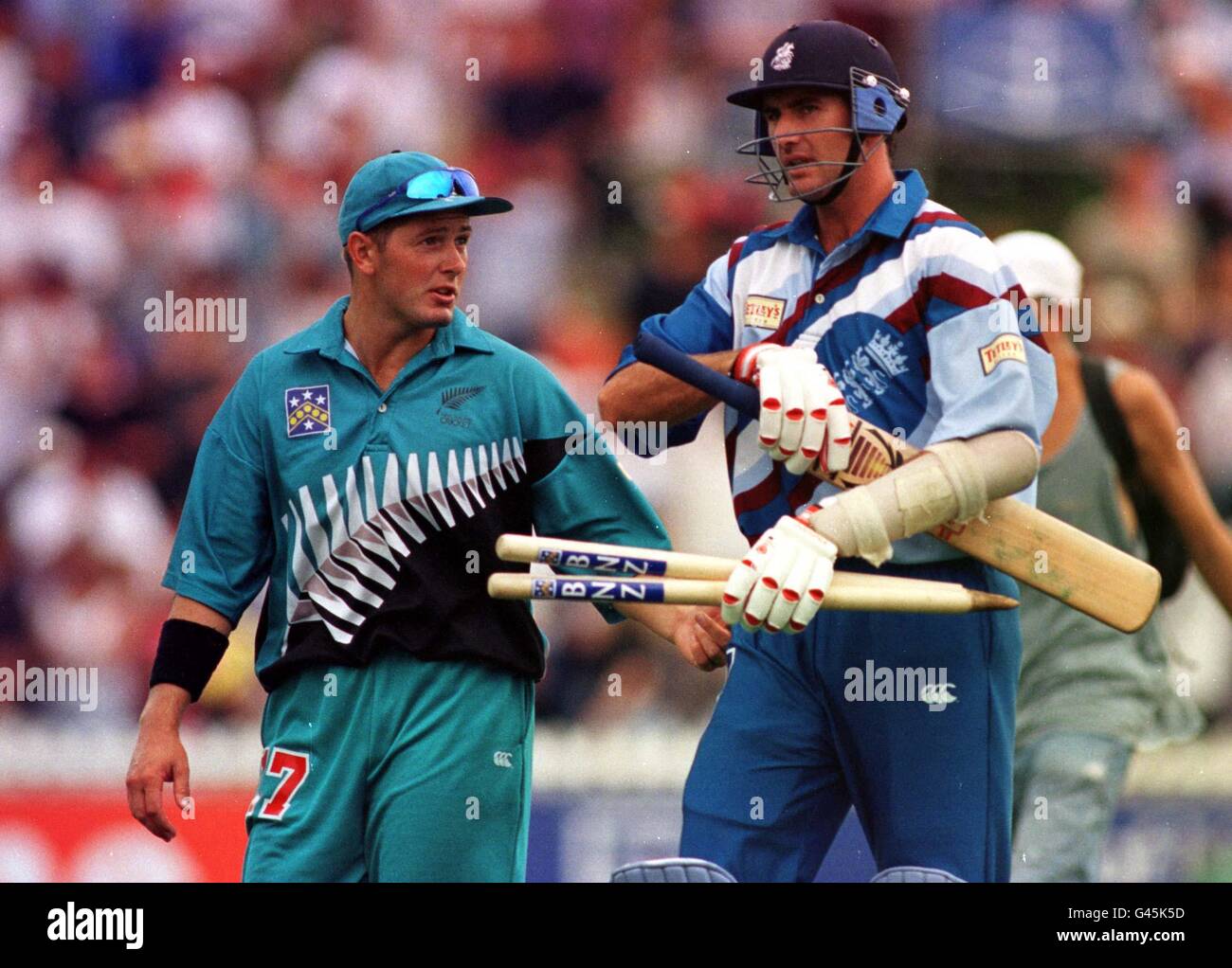England's Andrew Caddick (right), souvenirs two stumps as he leaves the ...