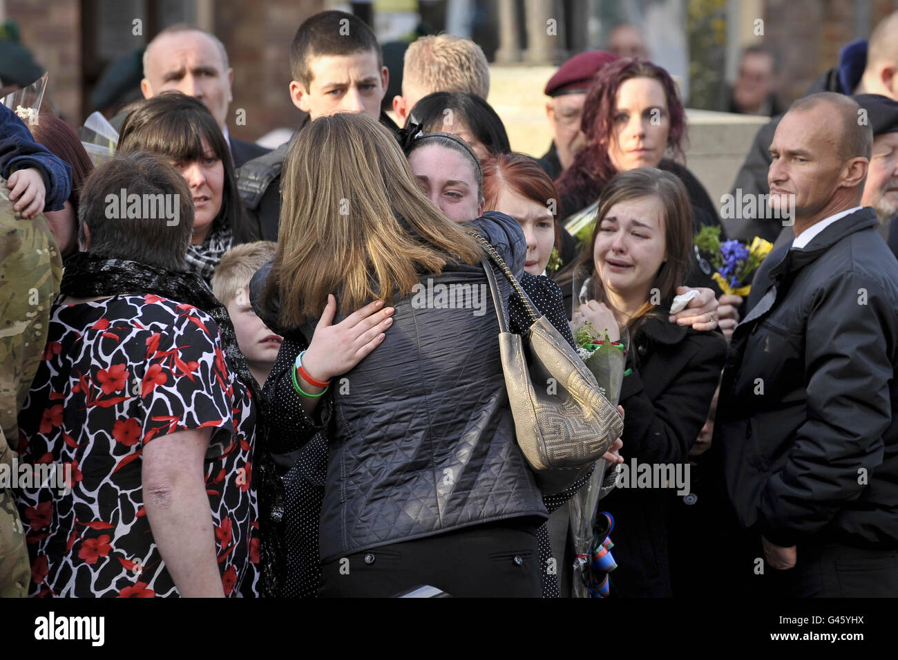Family and friends hug on the High Street as they wait for the ...