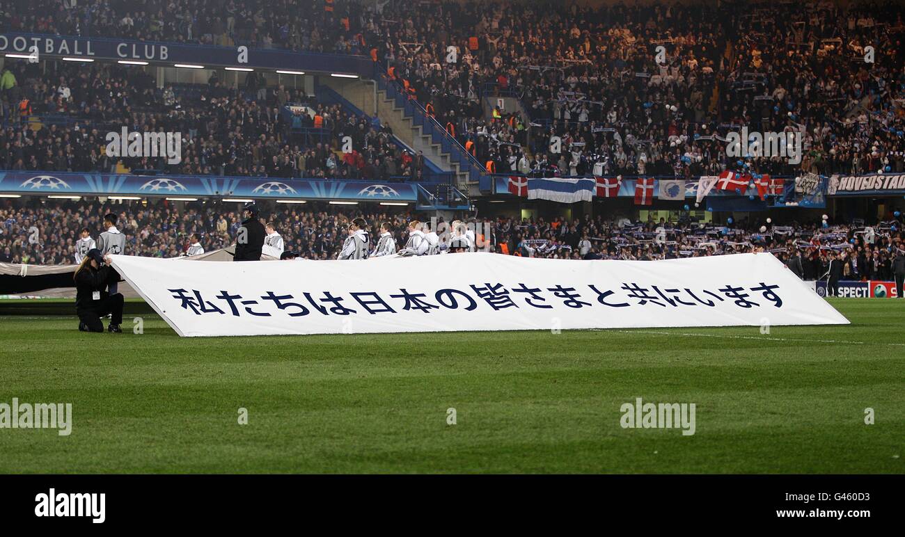 A banner in Japanese is unveiled before kick off as players and fans ...