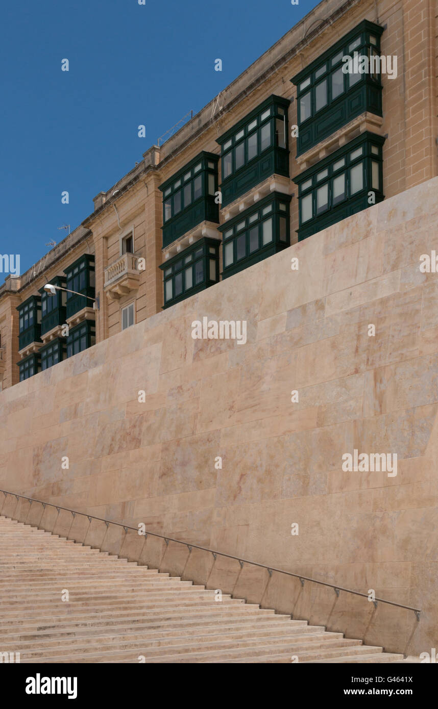 Traditional maltese balcony windows behind stone wall in valletta malta ...
