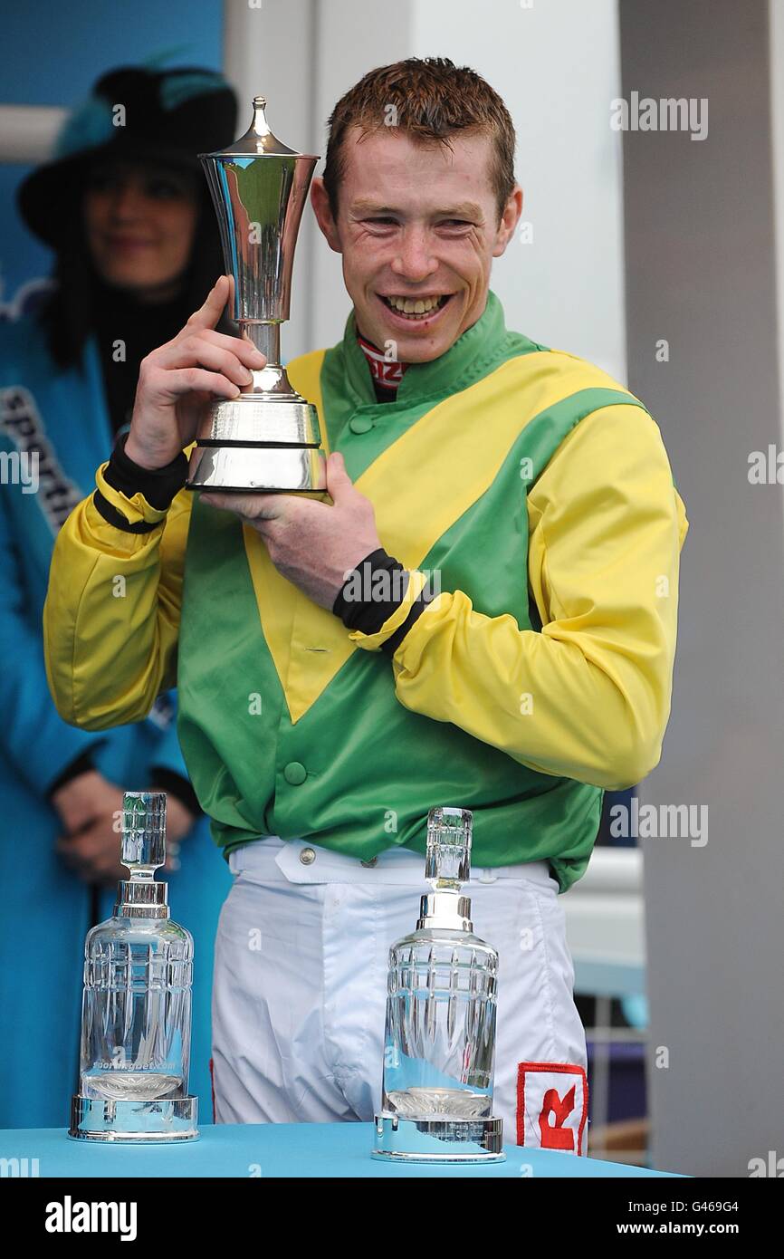 Jockey Andrew Lynch celebrates with the trophy after victory on Sizing ...