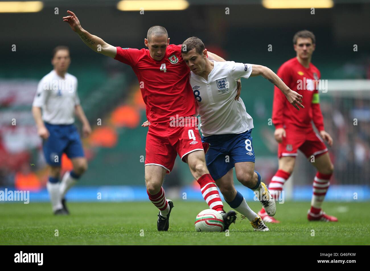 Wales' Andrew Crofts (left) and England's Jack Wilshere (right) battle ...
