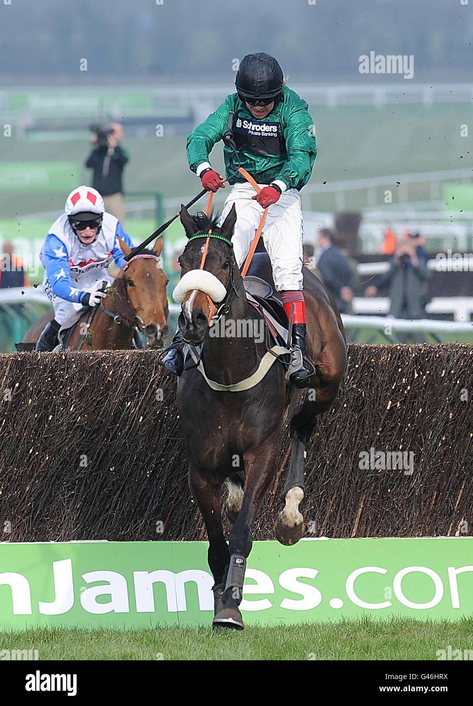 Jockey Robert Thornton jumps the last fence on the way to winning the ...