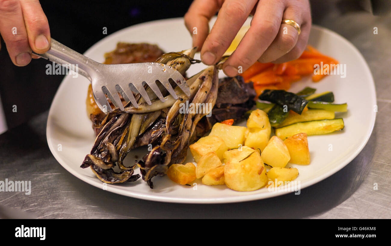 Preparing a dish of meat in the kitchen of a restaurant Stock Photo - Alamy