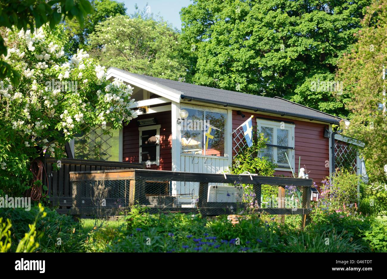 Idyllic red cottage in botanical garden Stock Photo - Alamy