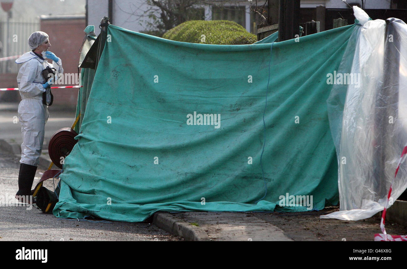 A Police forensic officer looks into the scene of a fire at a derelict ...
