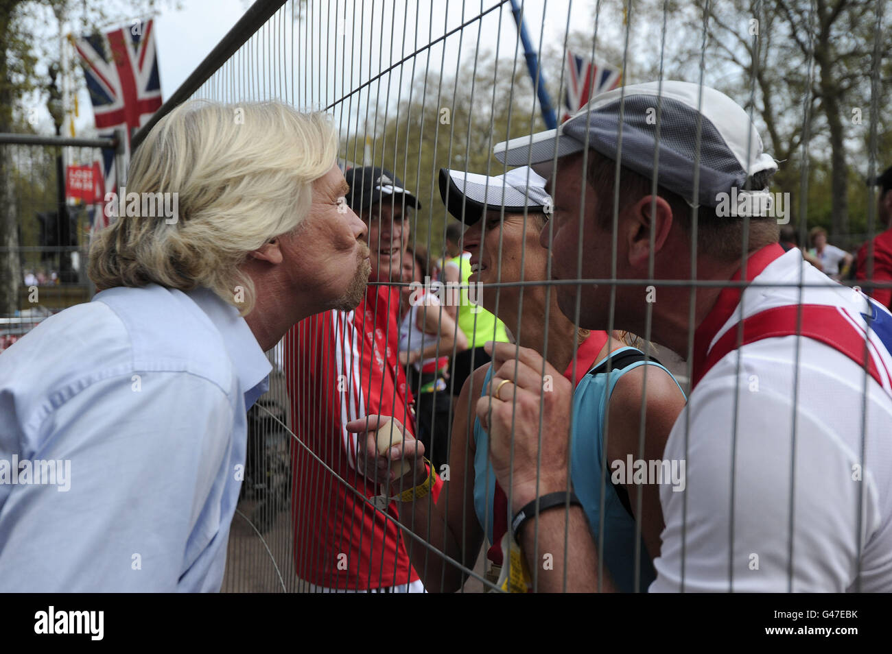 Sir Richard Branson kisses a marathon runner through a fence as she ...
