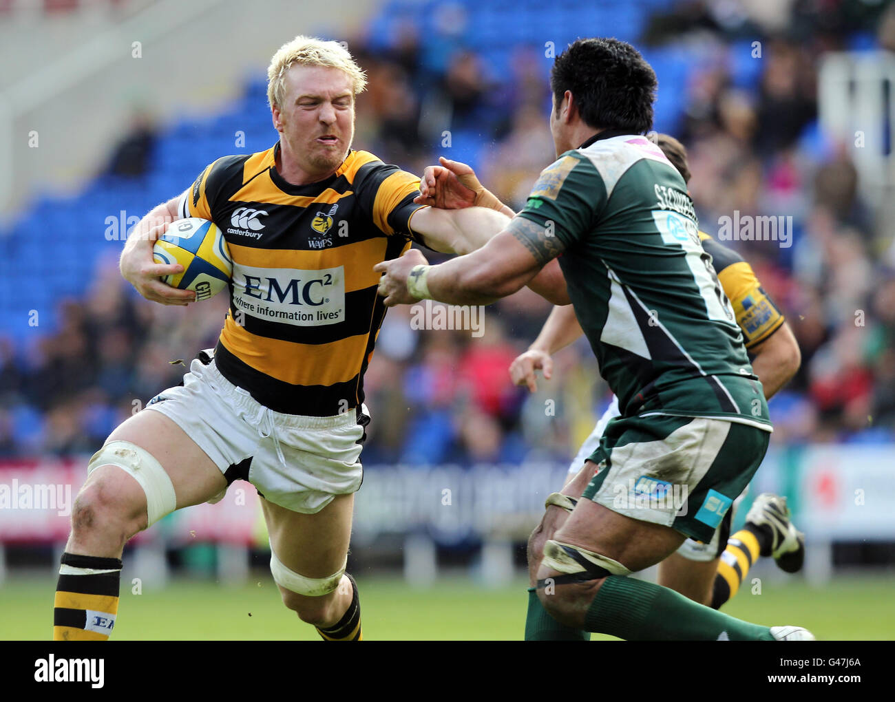 Wasps Andy Powell hands off London Irish's George Stowers during the ...