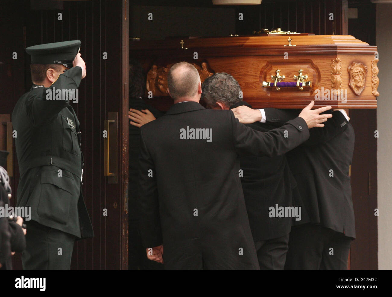 A police officer salutes during the funeral of PSNI officer Ronan Kerr ...