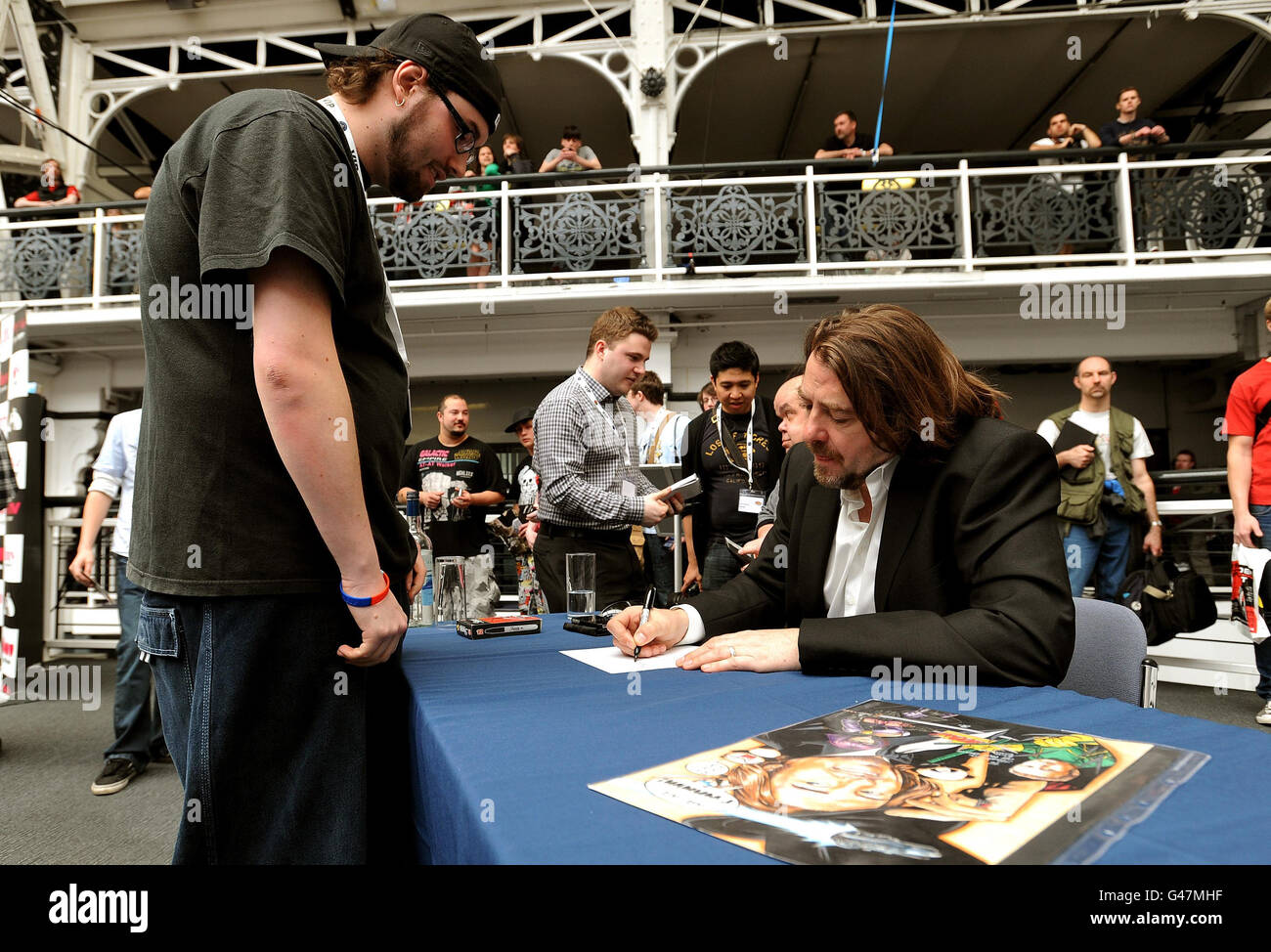 Jonathan Ross signs an autograph for a fan of comic books, at the Kapow ...