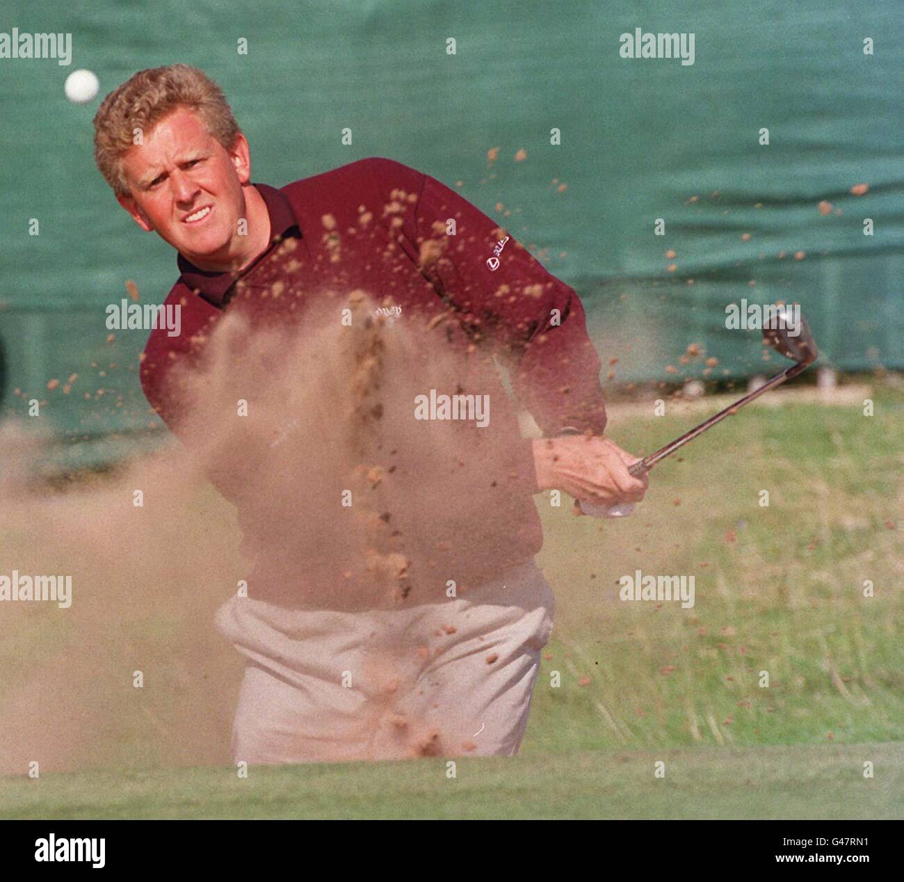 Scotland's Colin Montgomerie hits out of a bunker during his round ...