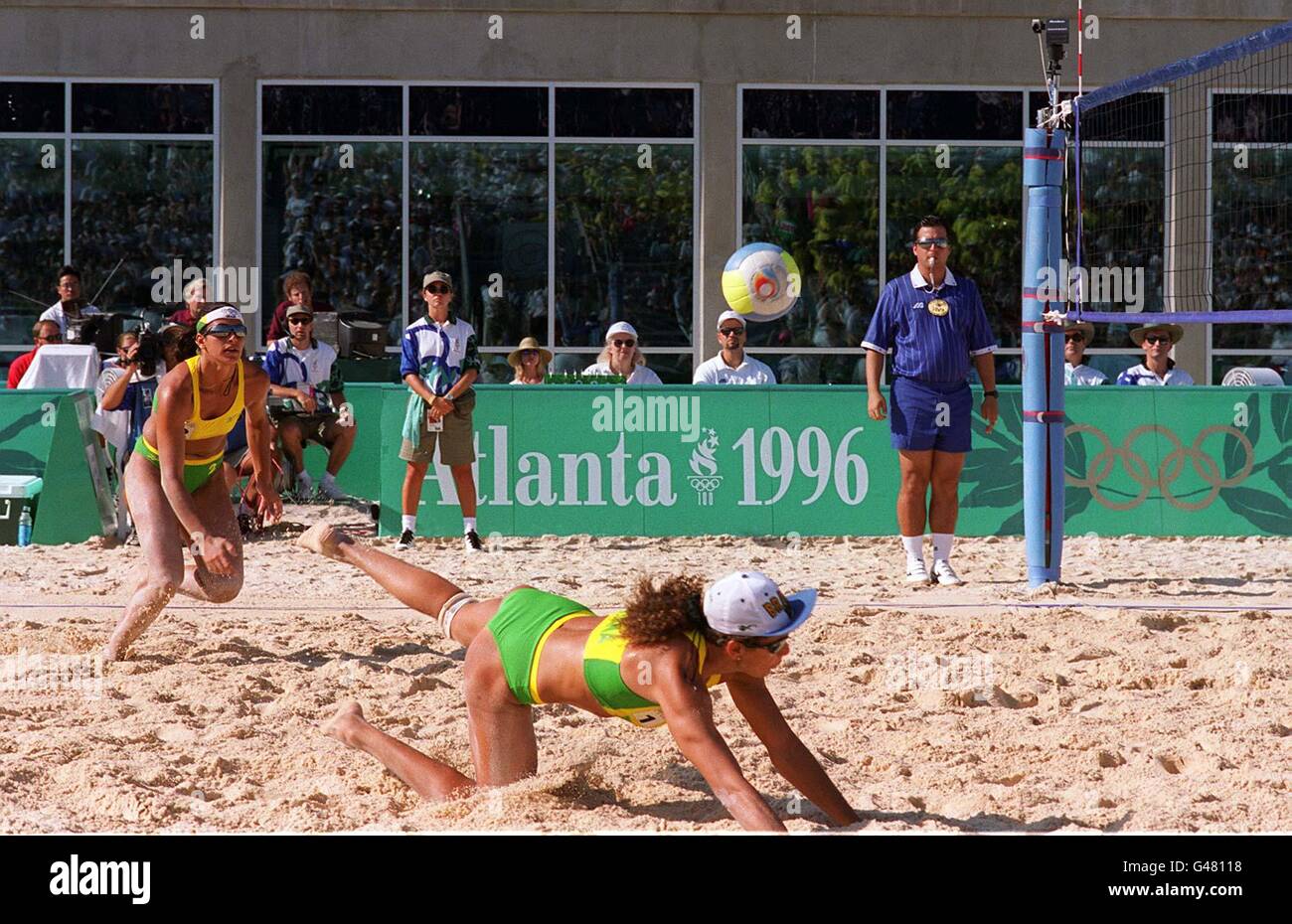 Brazil's Monica Rodrigues hits the sand as her teammate, Adrianna Ramos ...