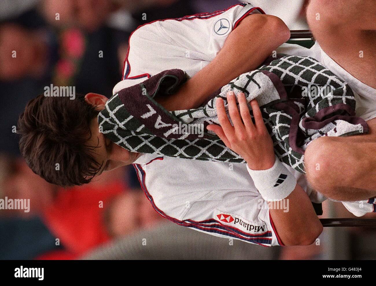 Britain's Tim Henman wipes his face with a towel during his marathon ...
