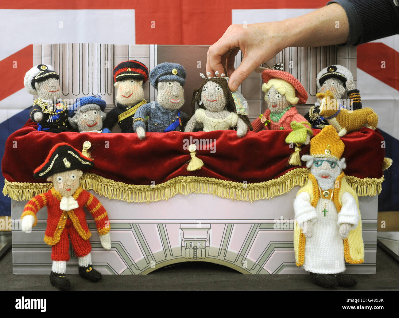 Fiona Goble adjusts knitted figures she created of attendees at the ...