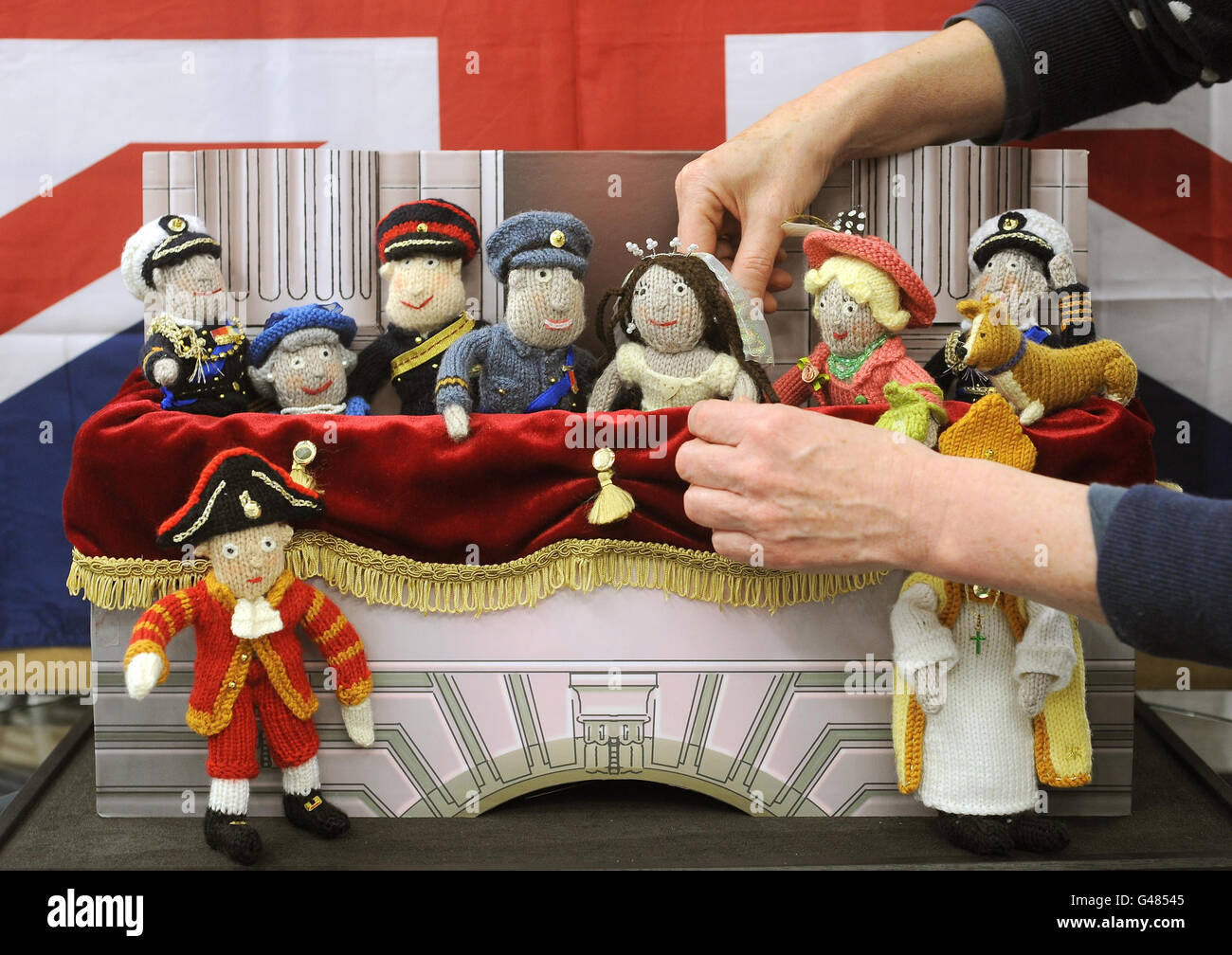 Fiona Goble adjusts knitted figures she created of attendees at the ...