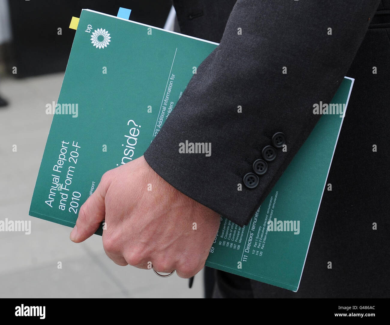 A BP shareholder holds an annual report as he leaves the BP AGM at the ...
