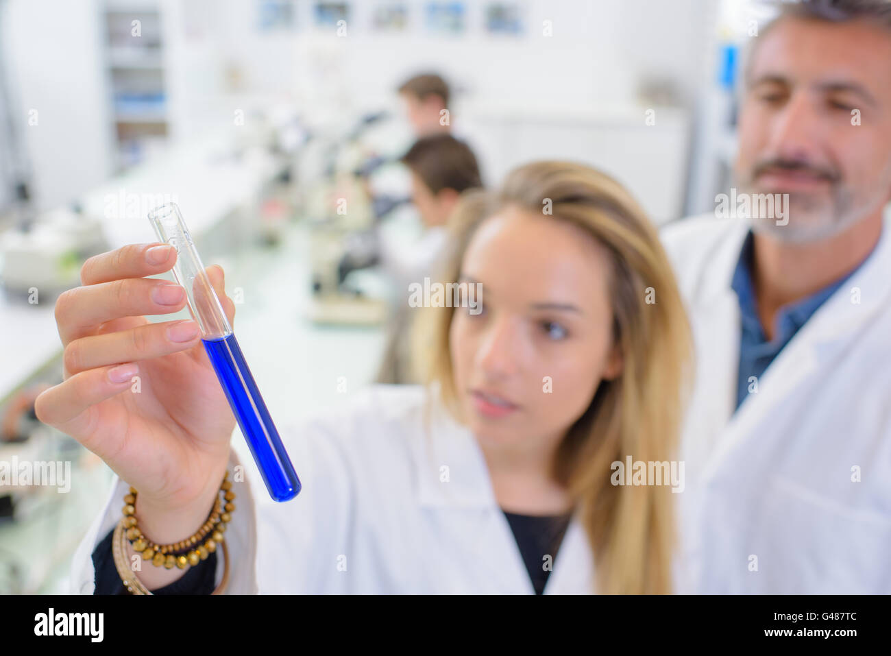 Female scientist looking at test tube Stock Photo - Alamy