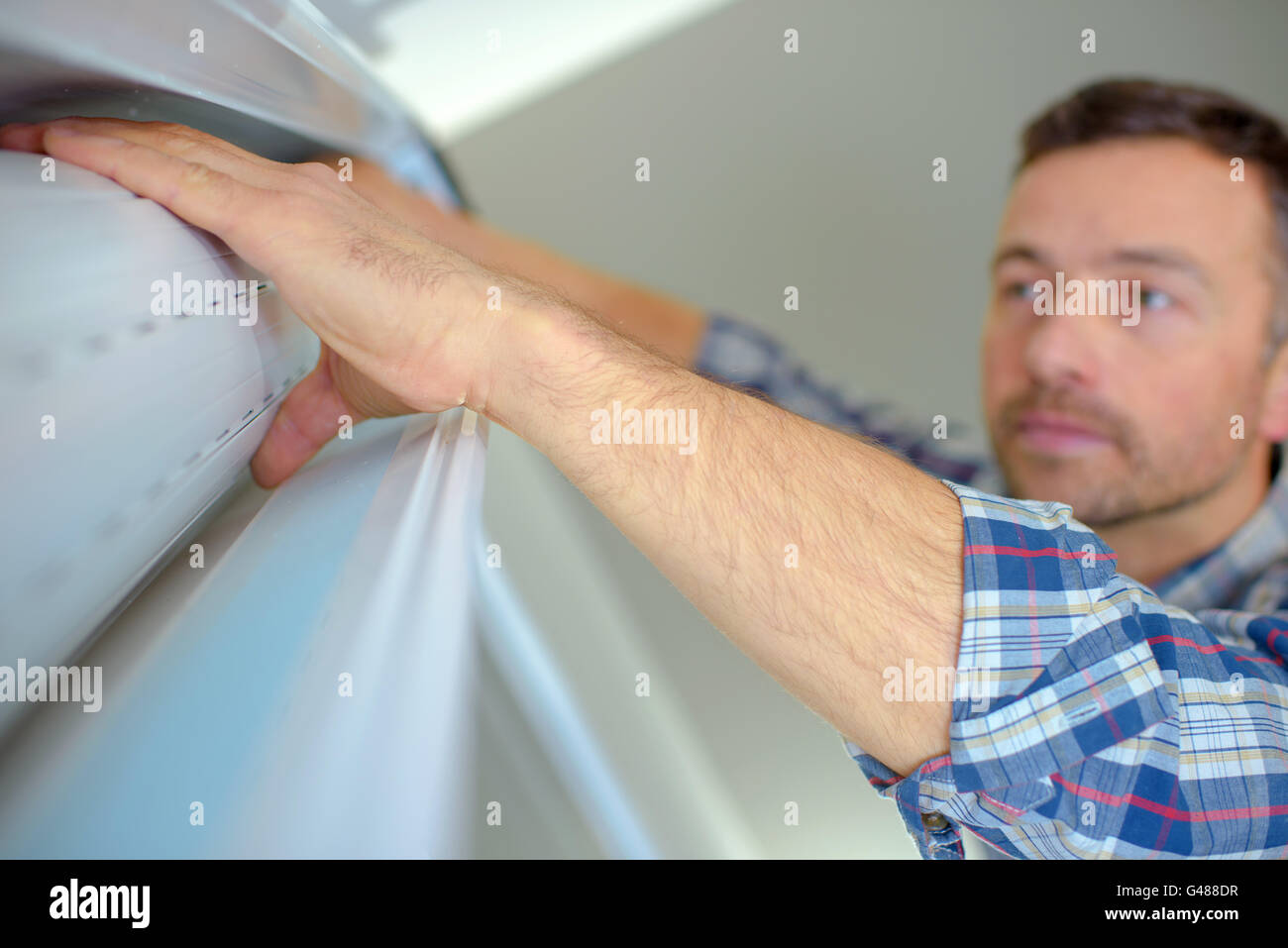 Handyman installing a window shutter Stock Photo - Alamy