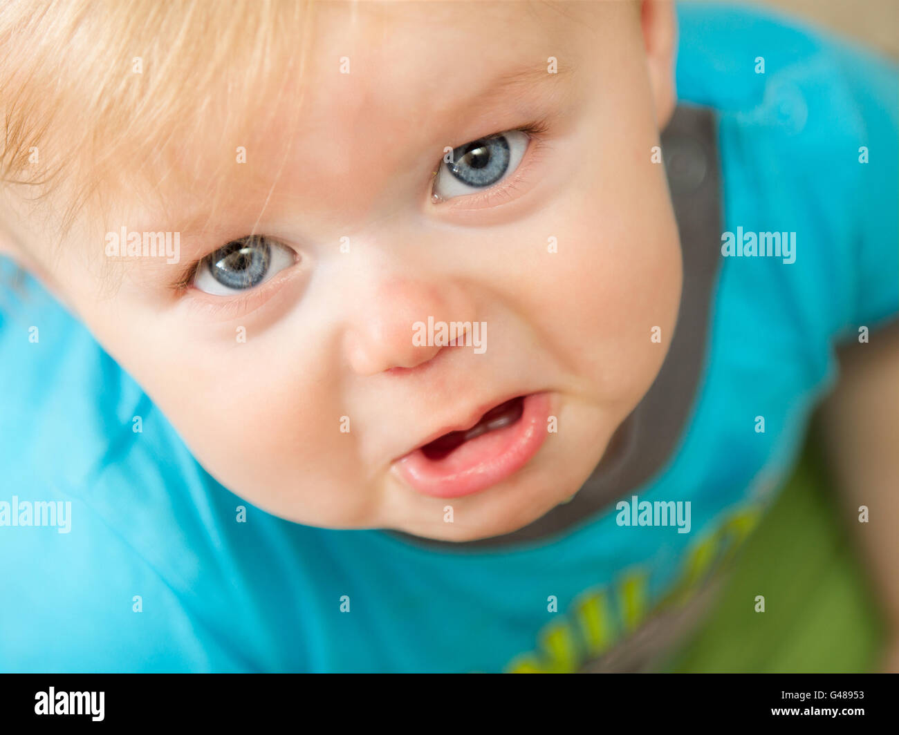 A little toddler boy is making a very sad face up at the camera. depth ...