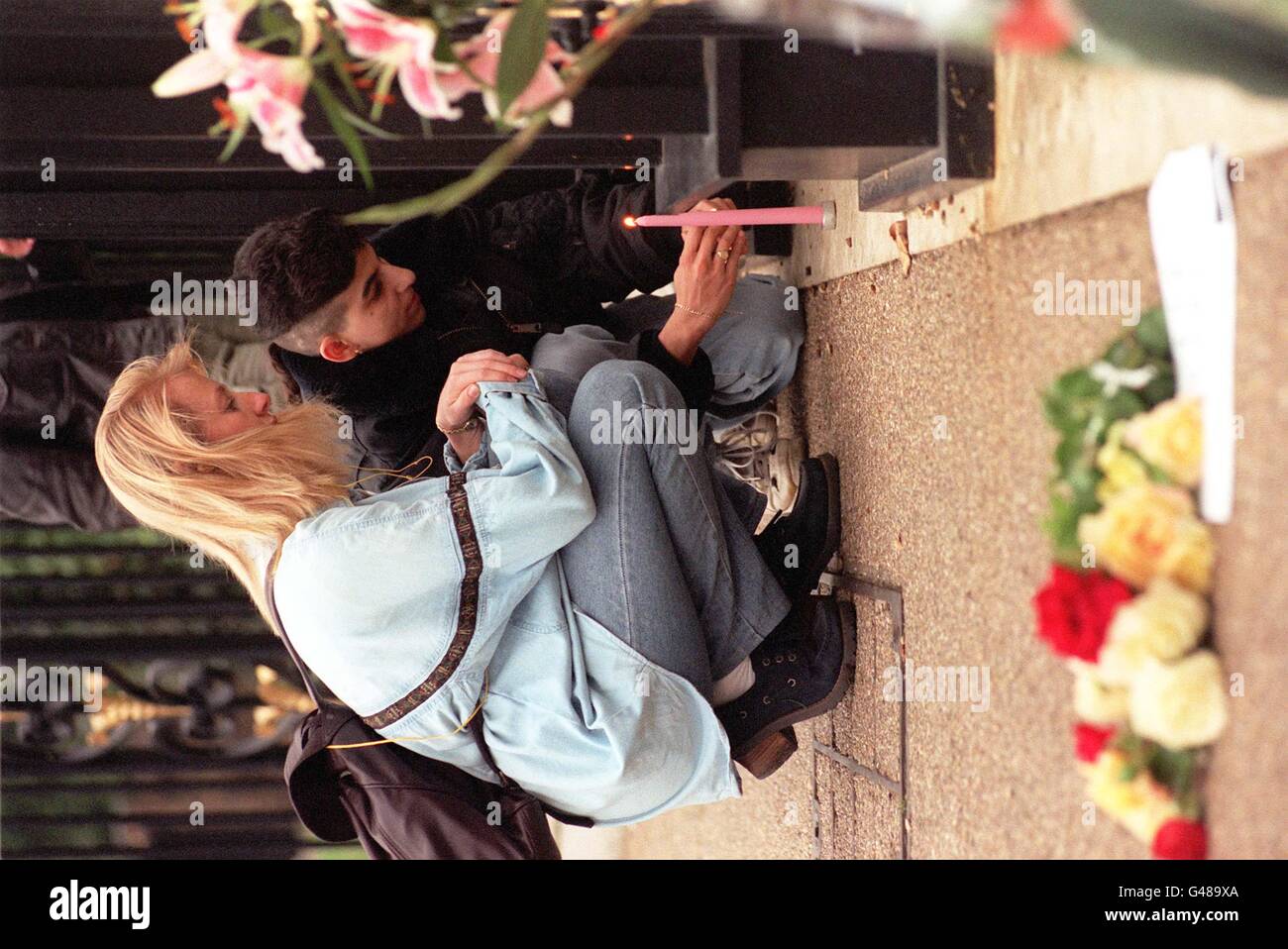 Passers by light candle outside the gates of kensington palace diana hi ...
